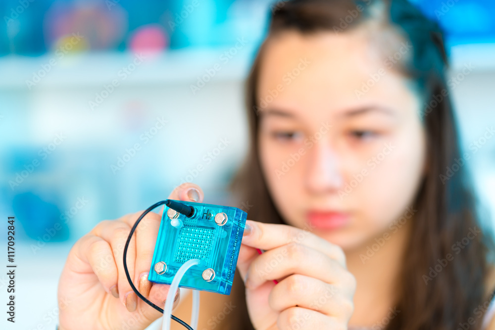 Student teen girl with experiment PEM proton exchange membrane ...