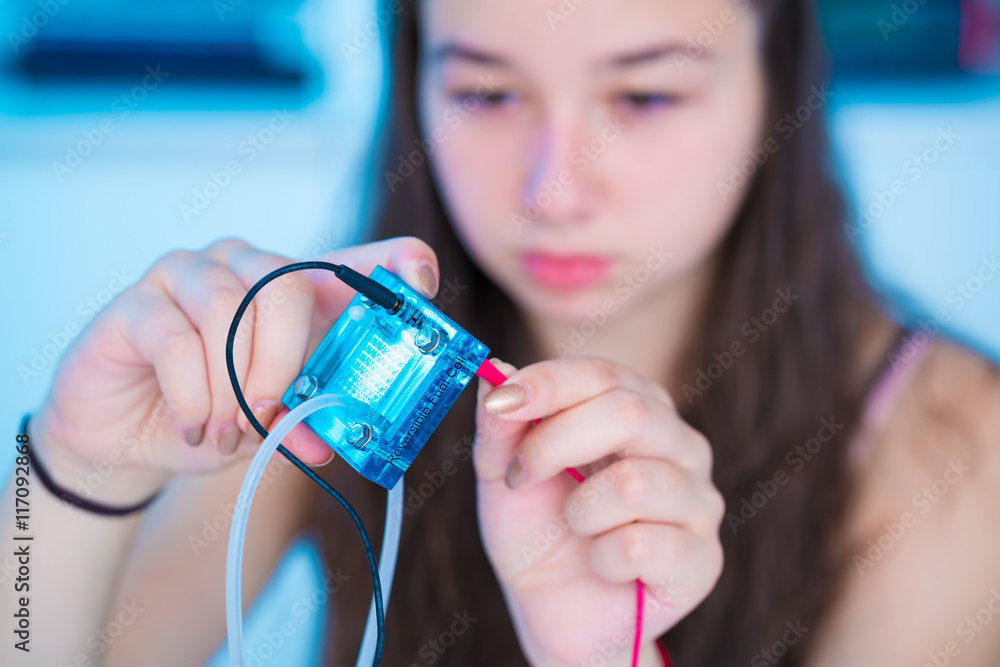 Student teen girl with experiment PEM proton exchange membrane ...