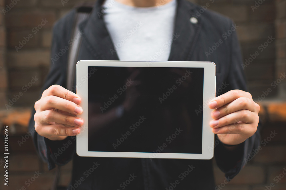 young guy with the tablet against the wall, holding technology Stock 写真 ...