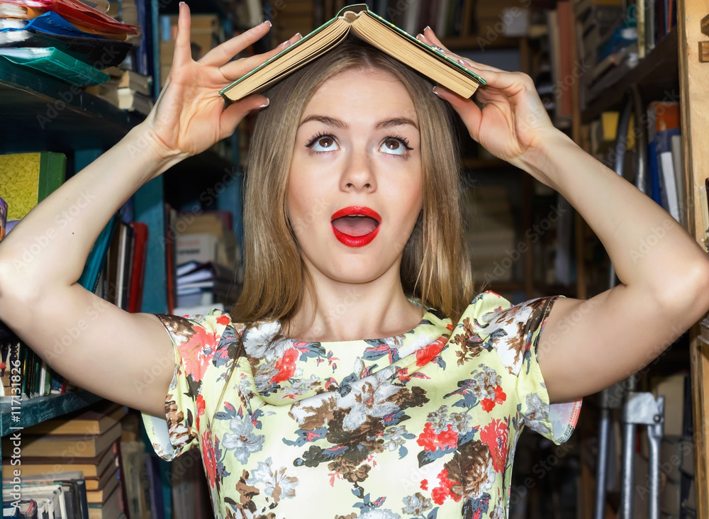 girl in library holding book on his head, to give knowledge and Stock ...