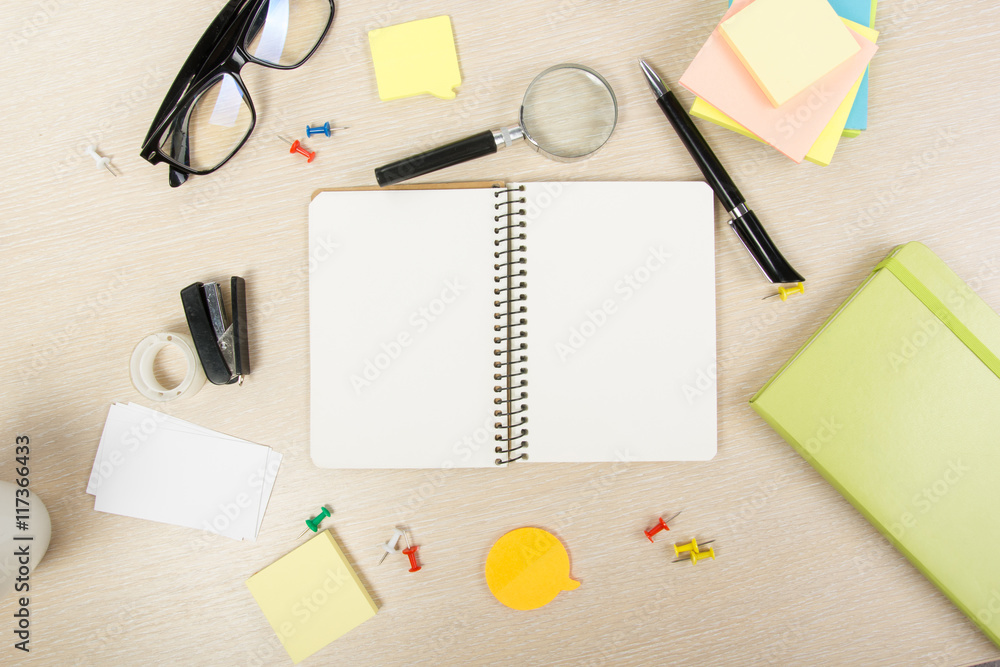 White blank open note book. Office table desk with set of colorful ...
