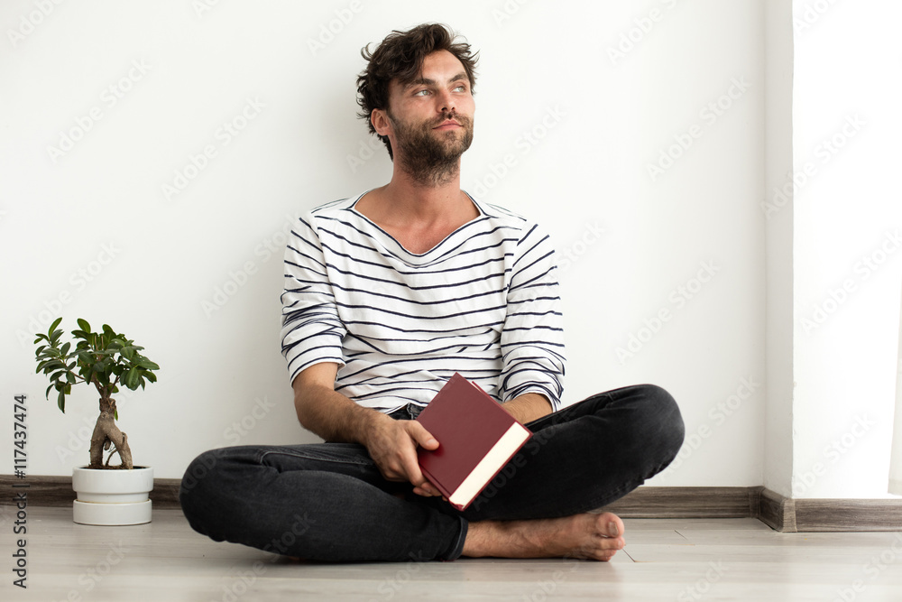 man reading a book and standing on the floor Stock Photo | Adobe Stock