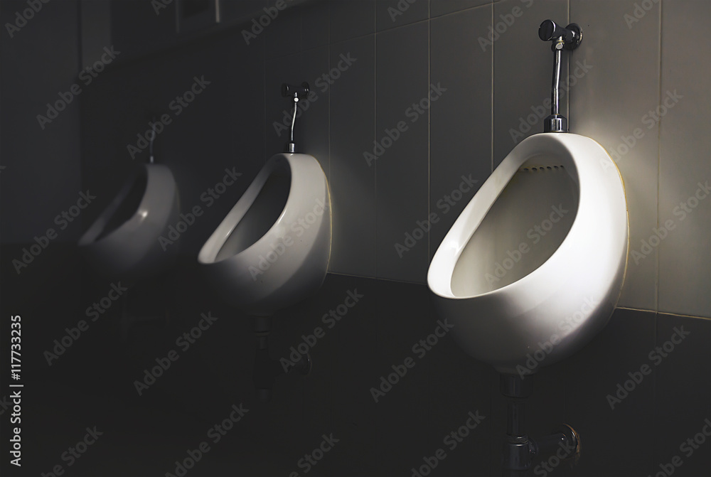 three urinal lavatory in dark room, [blur and select focus background ...