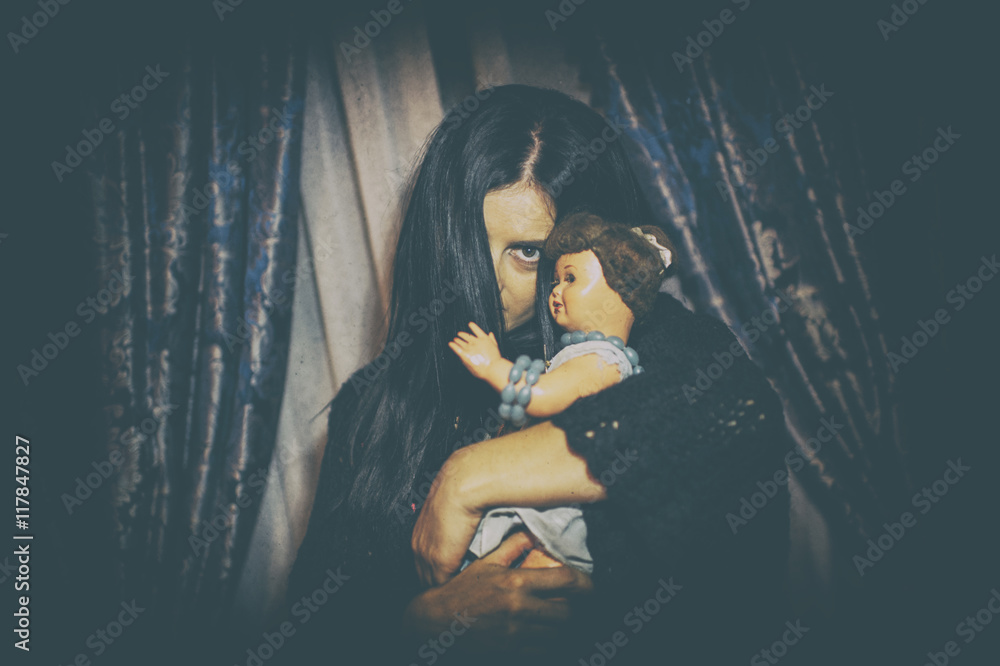 Scary woman hugging creepy doll Stock Photo | Adobe Stock