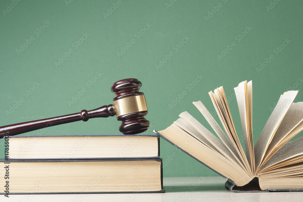 Law concept - Book with wooden judges gavel on table in a courtroom or ...