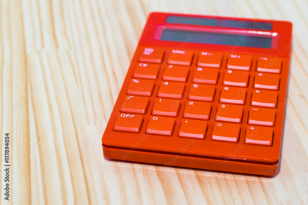 Red calculator on wooden texture Stock Photo | Adobe Stock