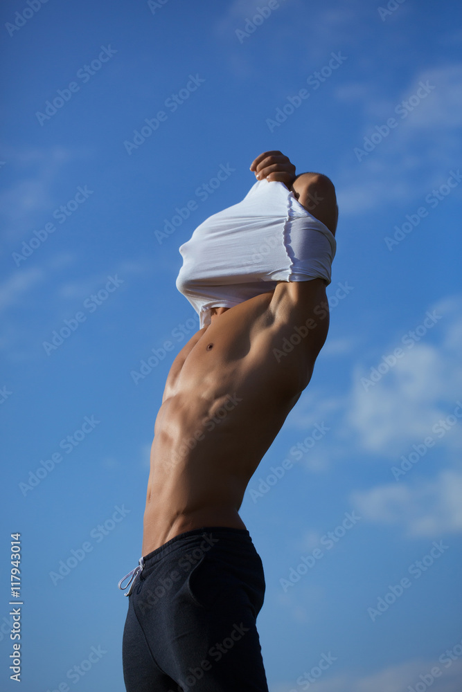 Sexy Muscular Man Undressing On Sky Background Stock Photo Adobe Stock