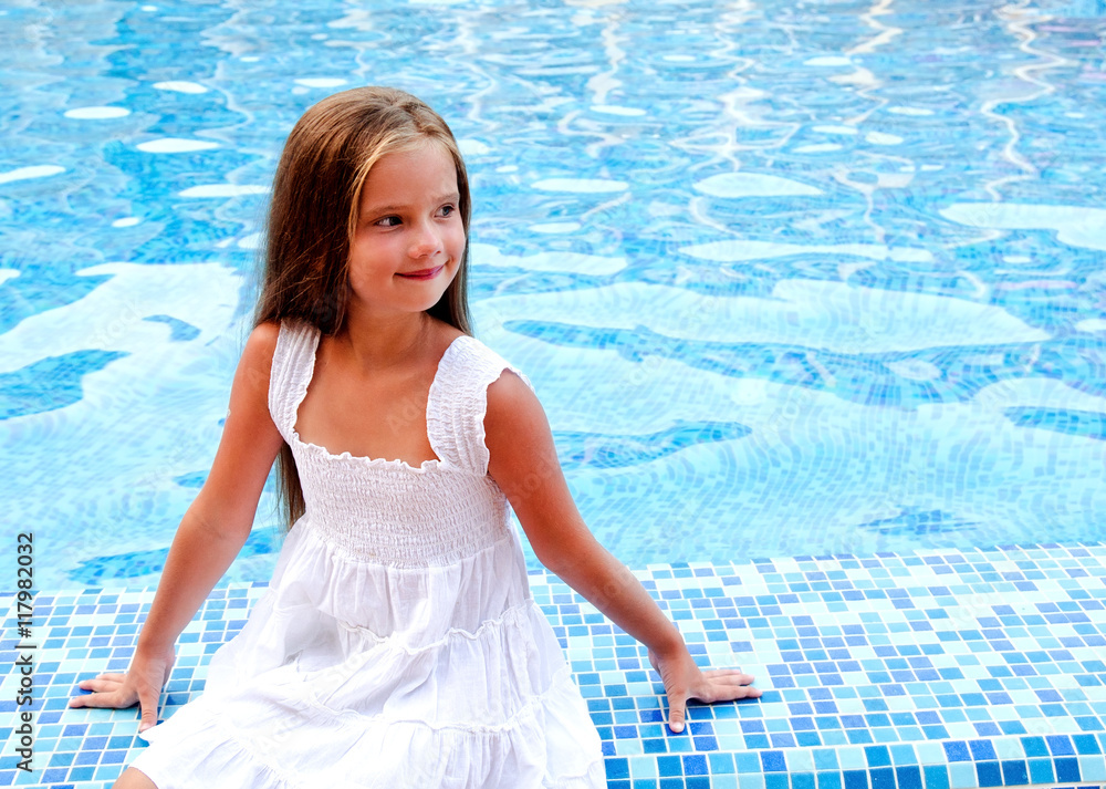 Adorable smiling little girl sitting near the swimming pool Stock Photo ...