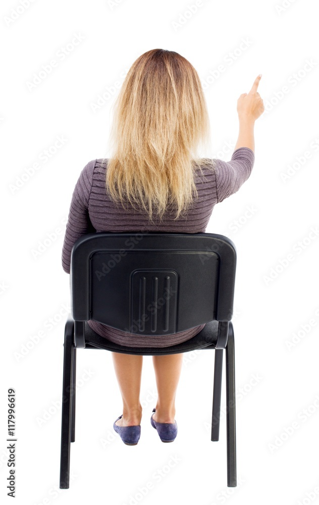 back view of young beautiful woman sitting on chair and pointing. girl ...