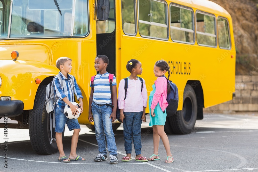 Smiling kids standing together in front of school bus Stock Photo ...