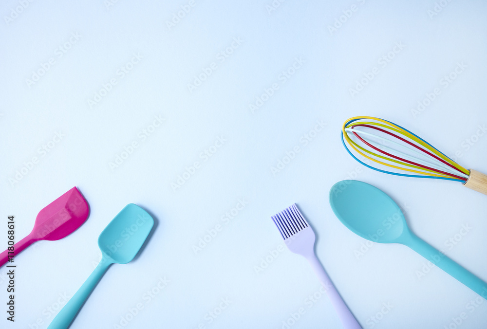 Colorful baking utensils arranged on a pastel blue background forming a ...