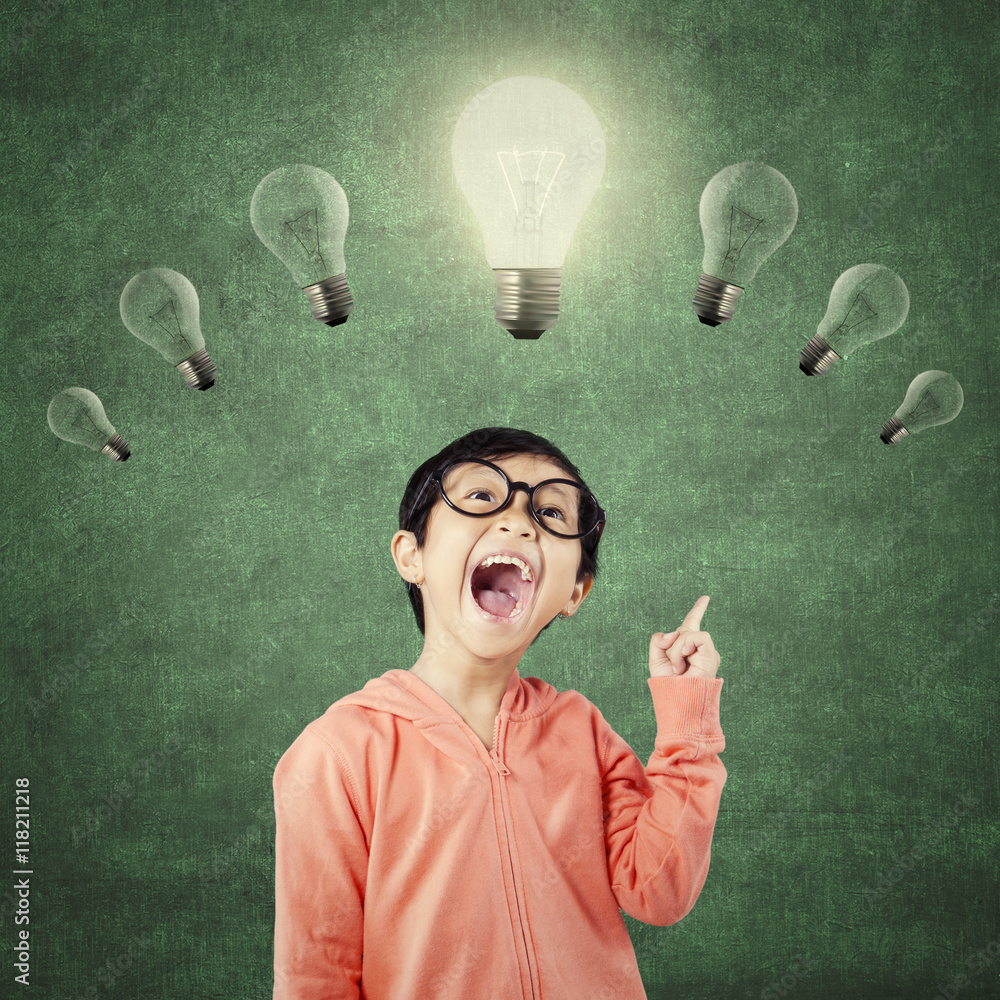 Genius child pointing at bright light bulb Stock Photo | Adobe Stock