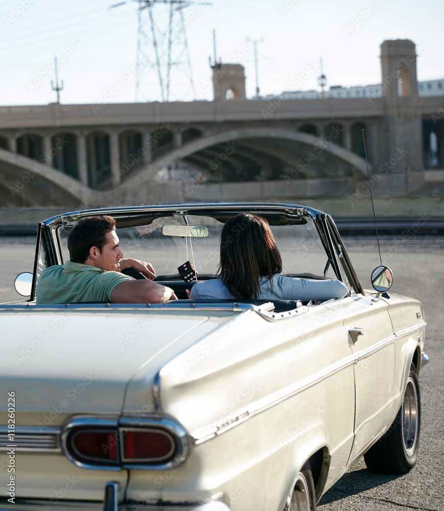 Rear view of couple in convertible classic car, Los Angeles, California ...