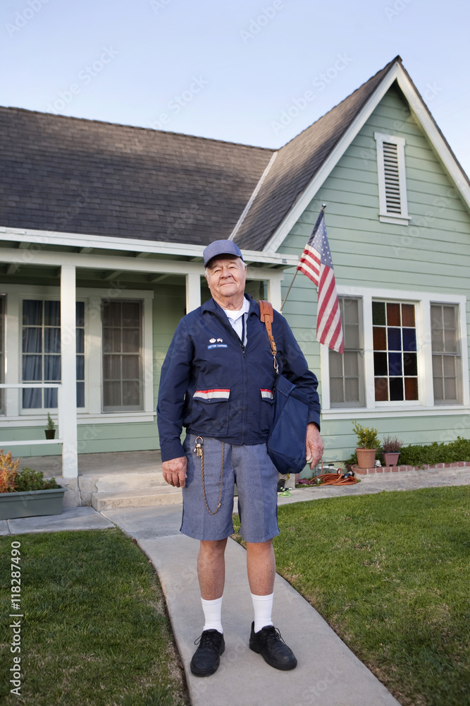 Caucasian mailman standing in front yard Stock Photo | Adobe Stock