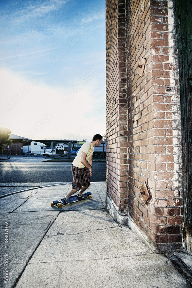 Caucasian man riding skateboard on city street Stock Photo | Adobe Stock
