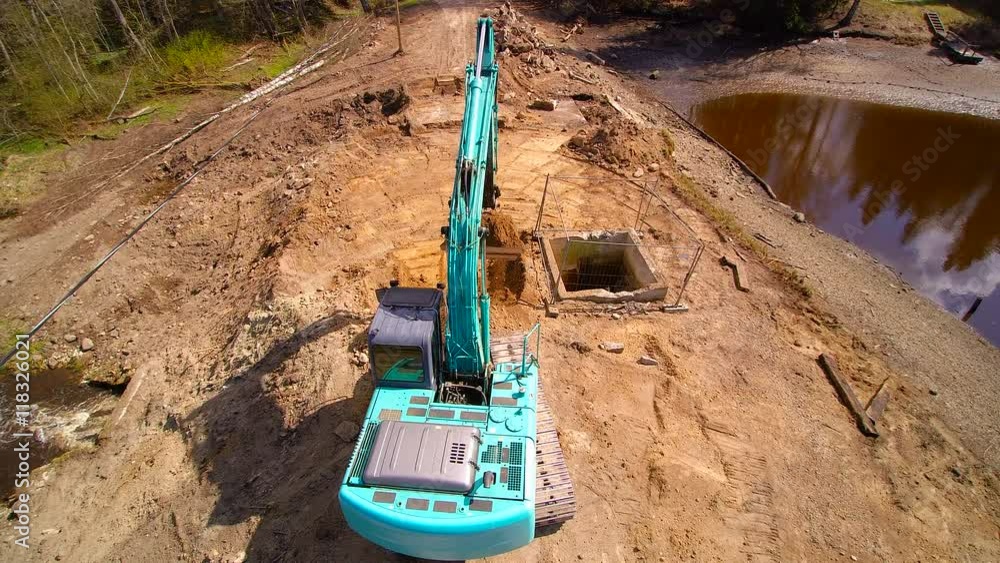Aerial view of the blue backhoe digging soil from the land inside the ...