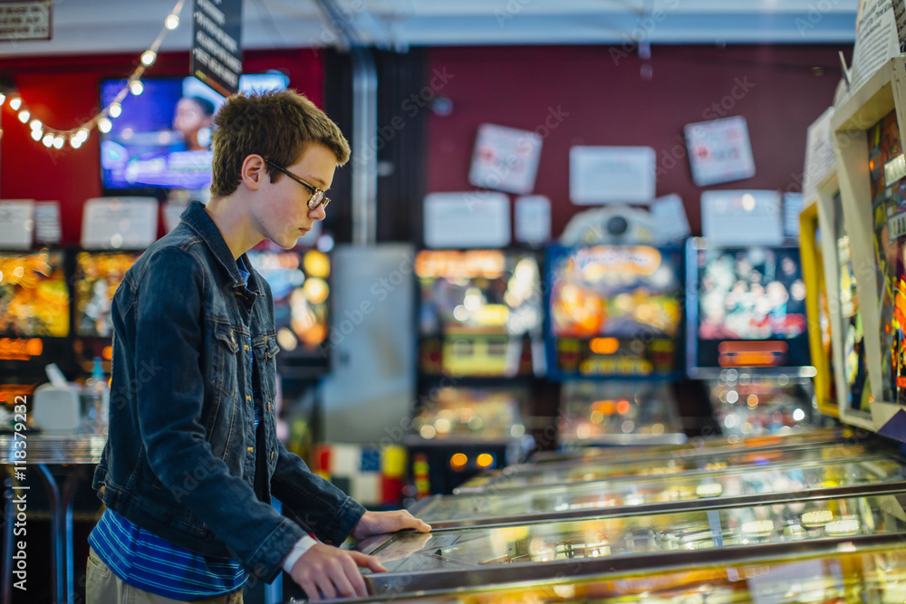 Caucasian teenage boy playing video game in arcade Stock Photo | Adobe ...