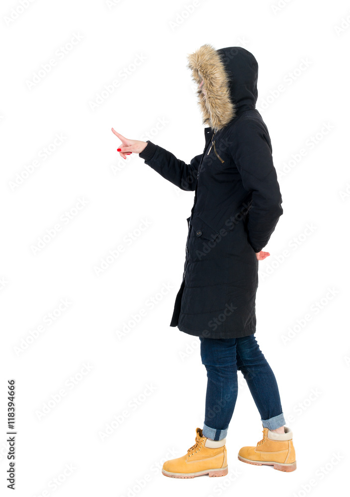 Back view of pointing young women in parka. Young girl gesture. Rear ...