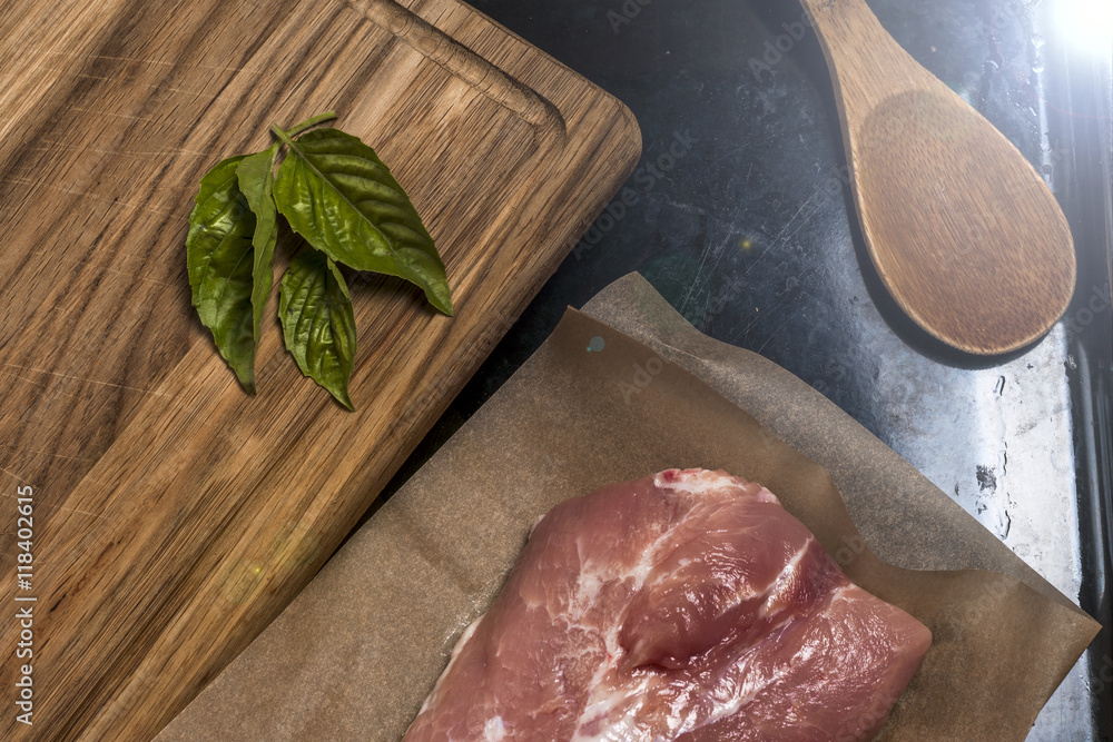 Fresh meat selection on black background with spices in a white bowl ...