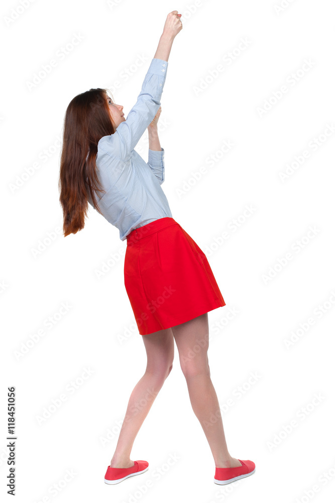 back view of standing girl pulling a rope from the top or cling to ...