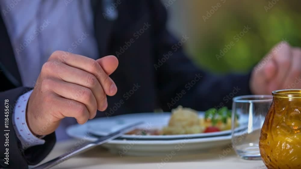 A man is in the middle of his meal. His fork and a knife are leaning on ...