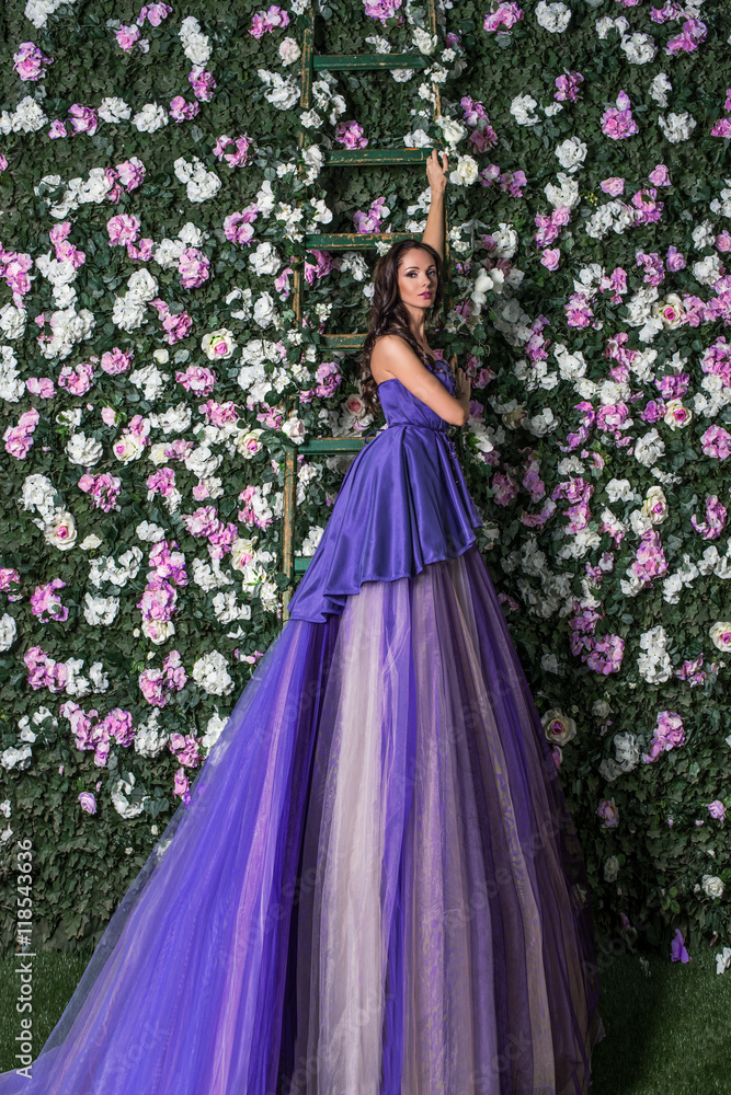 Beautiful brunette woman wearing long purple dress posing in the ...