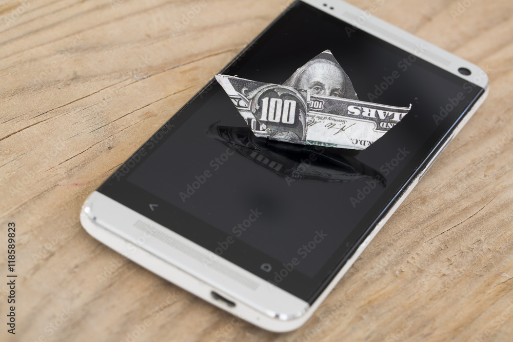 Smartphone on money Stock Photo | Adobe Stock