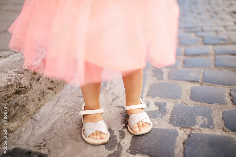 Tiny little feet of a girl in pink dress stand on the carriage w Stock ...