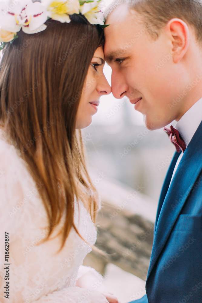 Beautiful newlywed bride and groom sensually touching foreheads in ...