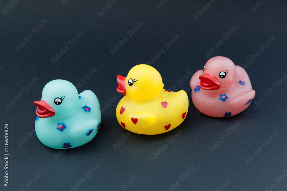 Several different colors of rubber ducks on black background Stock ...