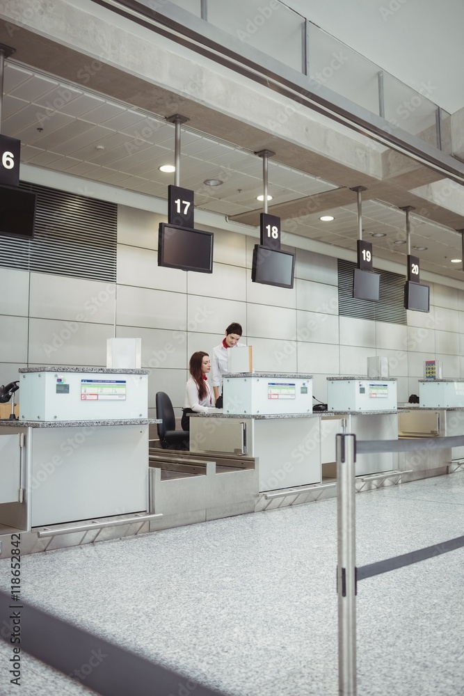 Airline check-in attendant working at check-in counter Stock Photo ...