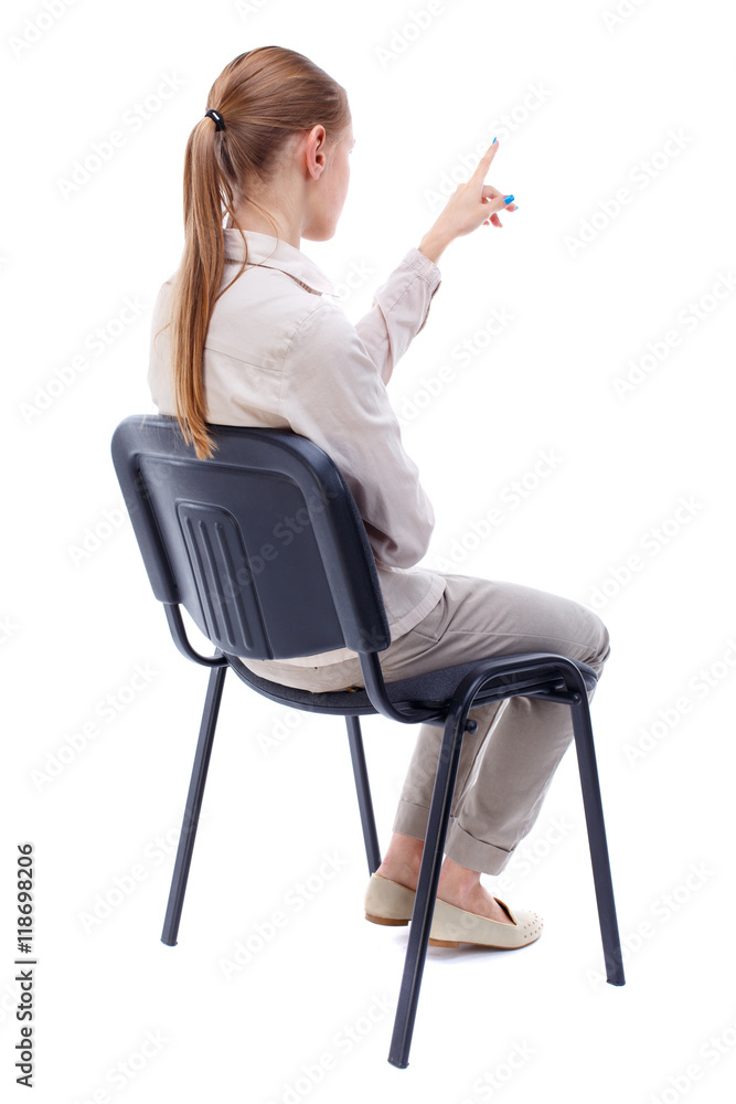 back view of young beautiful woman sitting on chair and pointing. girl ...