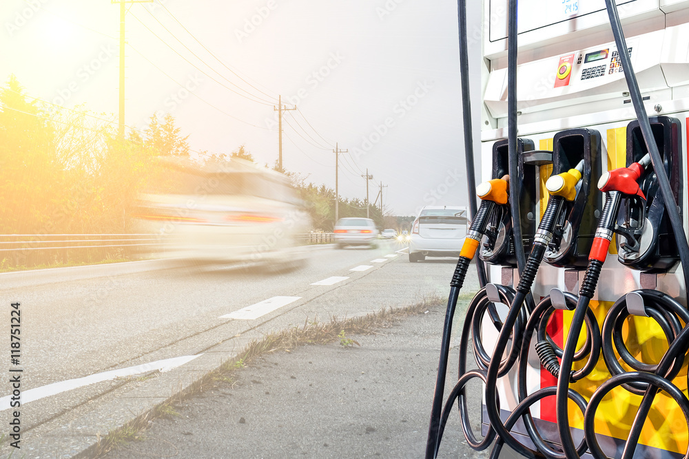 Gas pump nozzles in a service station against car motion blur ...