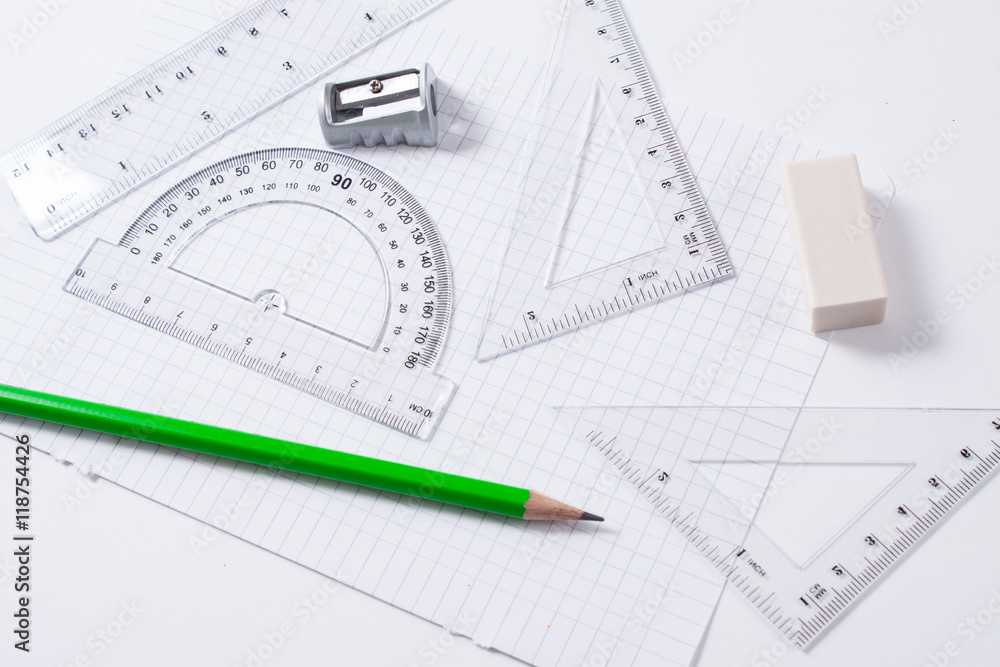 Protractor, rulers, pencil and eraser on squared paper Stock Photo ...