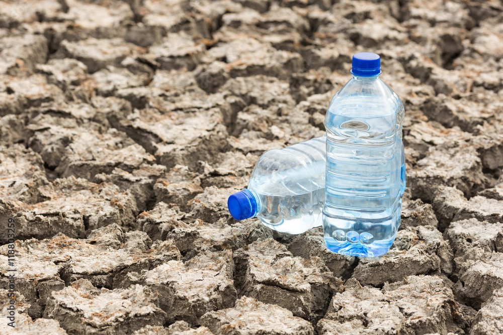 Bottle with water on the dried ground. Stock Photo | Adobe Stock