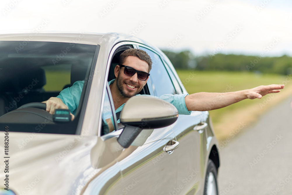 happy man in shades driving car and waving hand Stock Photo | Adobe Stock