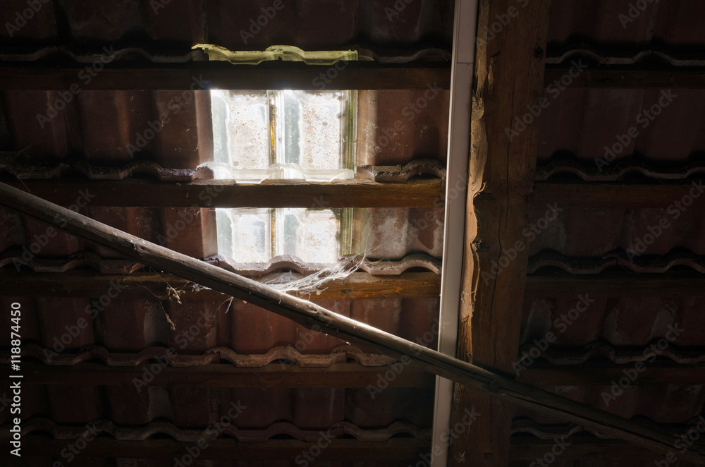 Foto Stock small old window on the inside of the house roof | Adobe Stock