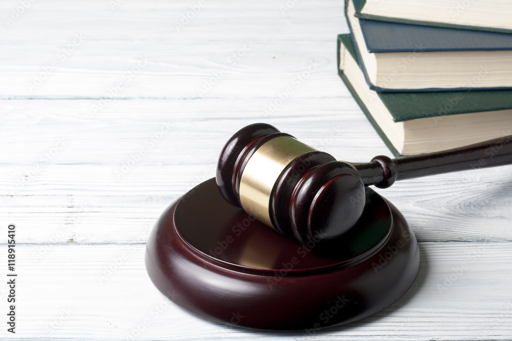 Law concept - Book with wooden judges gavel on table in a courtroom or ...
