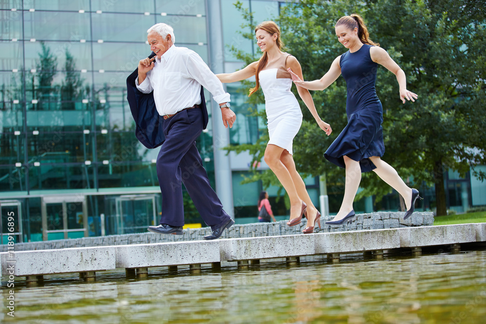 Two women chasing senior business man Stock Photo | Adobe Stock