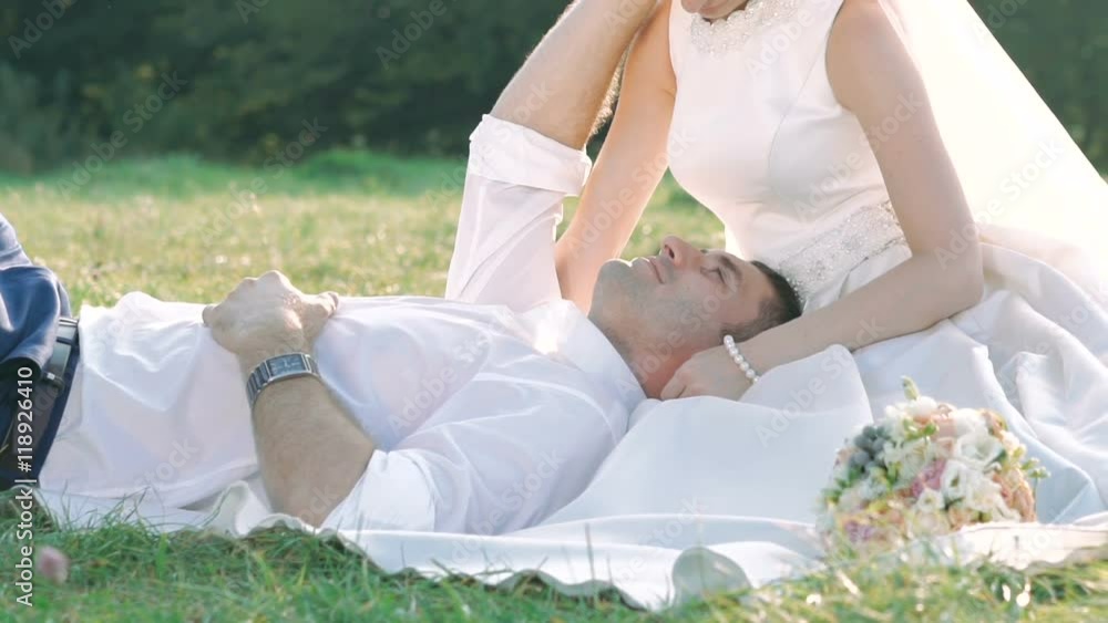 Bride and groom resting in the grass. 4K Stock Video | Adobe Stock