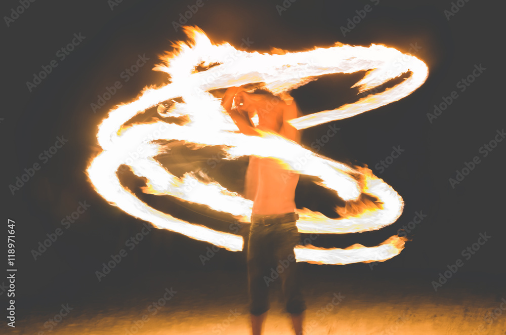 blurry focus a man rotating fireballs on the beach. Night light and ...