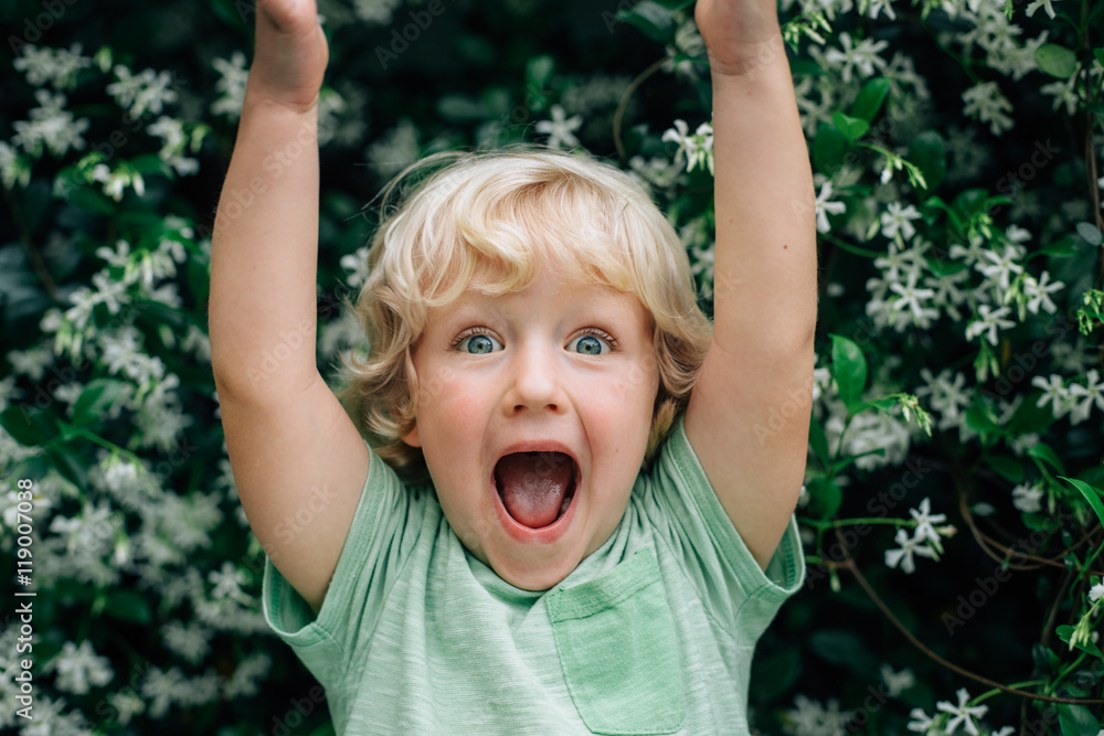 Small boy looking excited in front of greenery Stock Photo | Adobe Stock