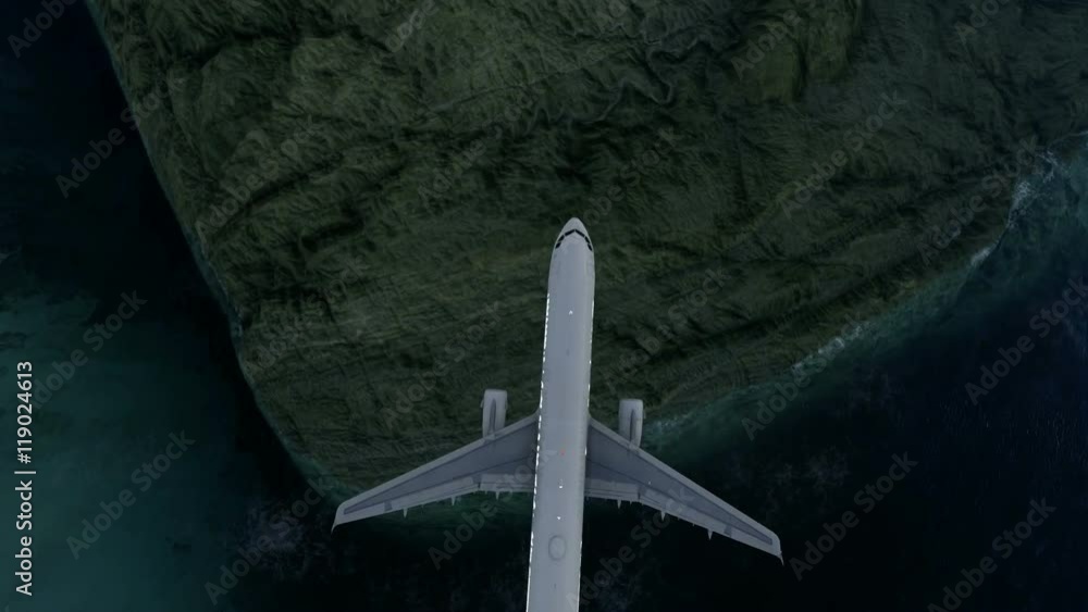 Passenger aircraft flying over the sea and the mountain at night time ...