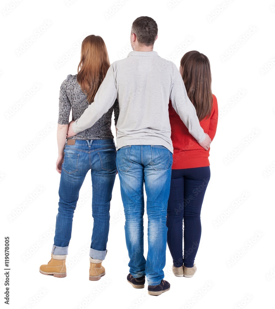 Back view of three friends (woman and man).Two young girls hug the guy ...