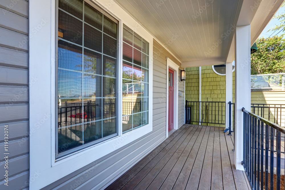 Empty covered porch with black metal railings and columns. Stock Photo ...