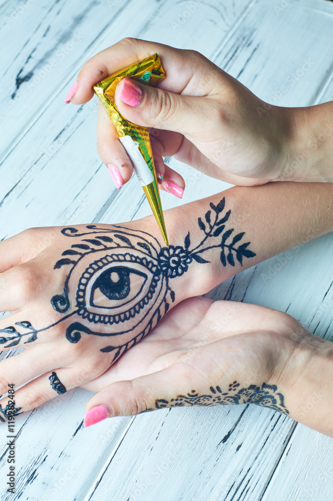Master painting with henna on the hands of women. The complex process ...