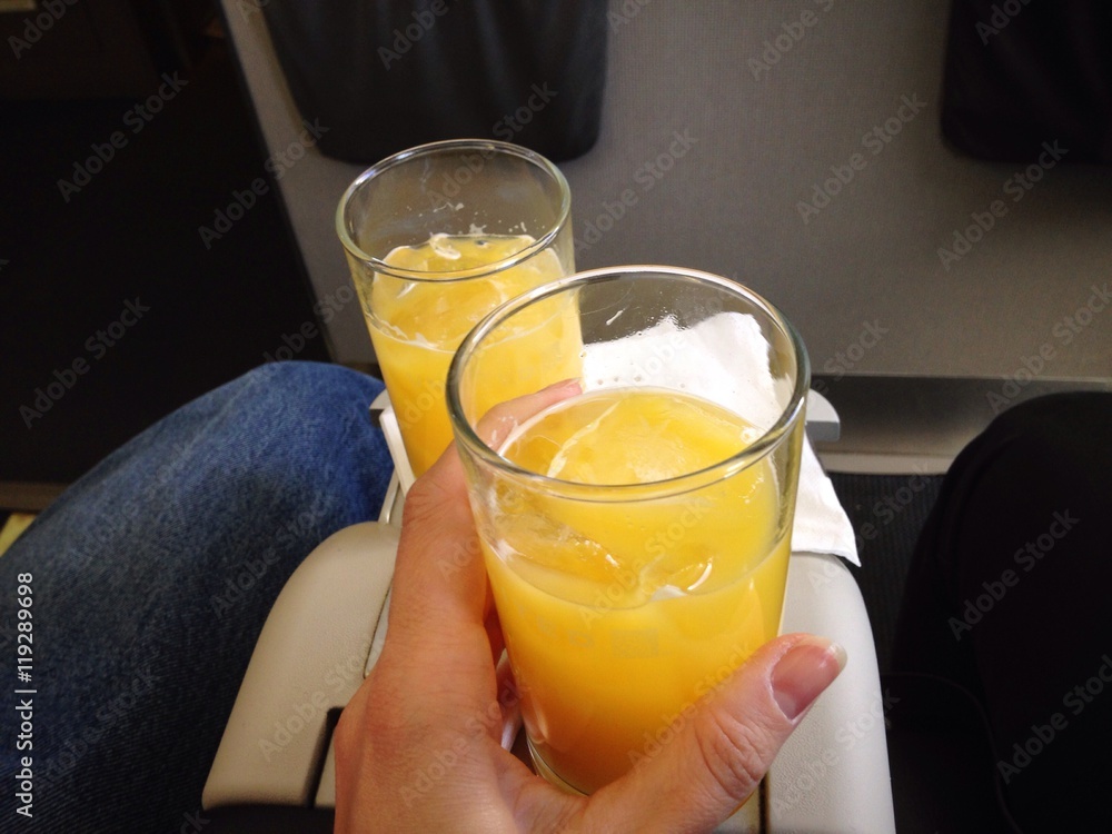 Foto Stock Orange juice serving in the business class on airplane ...