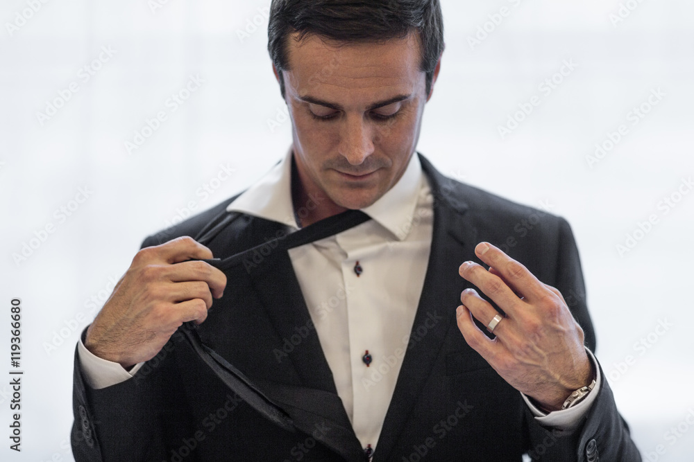Businessman taking off tie, Stockholm, Sweden foto de Stock | Adobe Stock