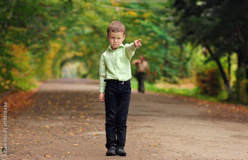 Angry little kid raches out his hand while showing something far Stock ...