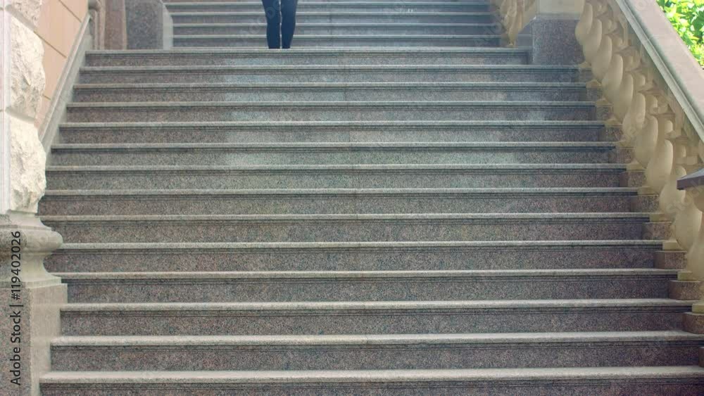 Woman running down stairs in slow motion. Fitness girl jogging down ...
